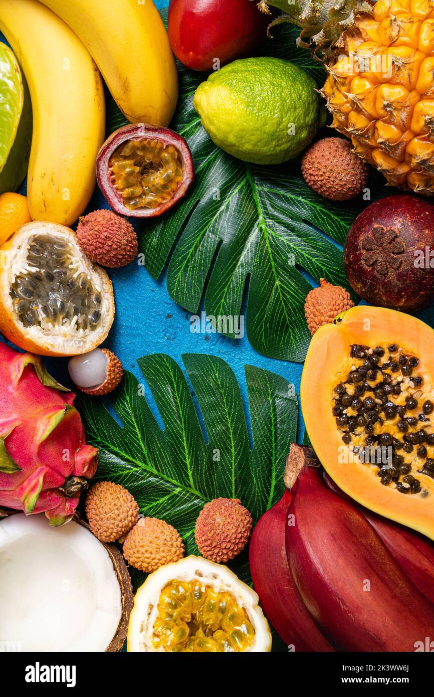 Fresh tropical fruits flat lay. Different exotic fruits on blue summer ...