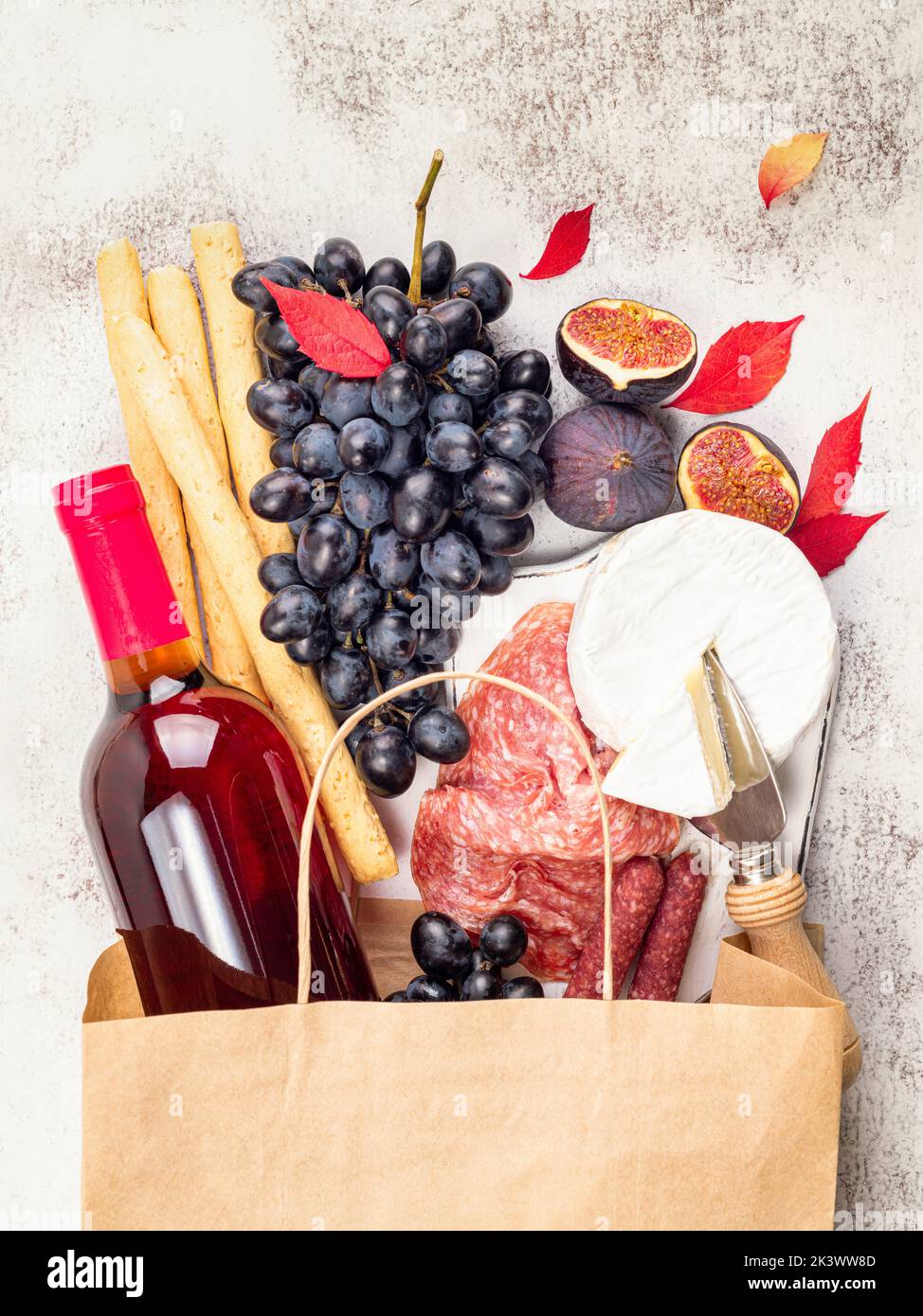 Rose wine and appetizers grape, figs, cheese camembert, bread stick ...