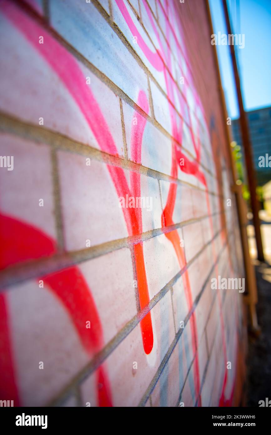 Bright red graffiti on a white brick wall, side view Stock Photo - Alamy