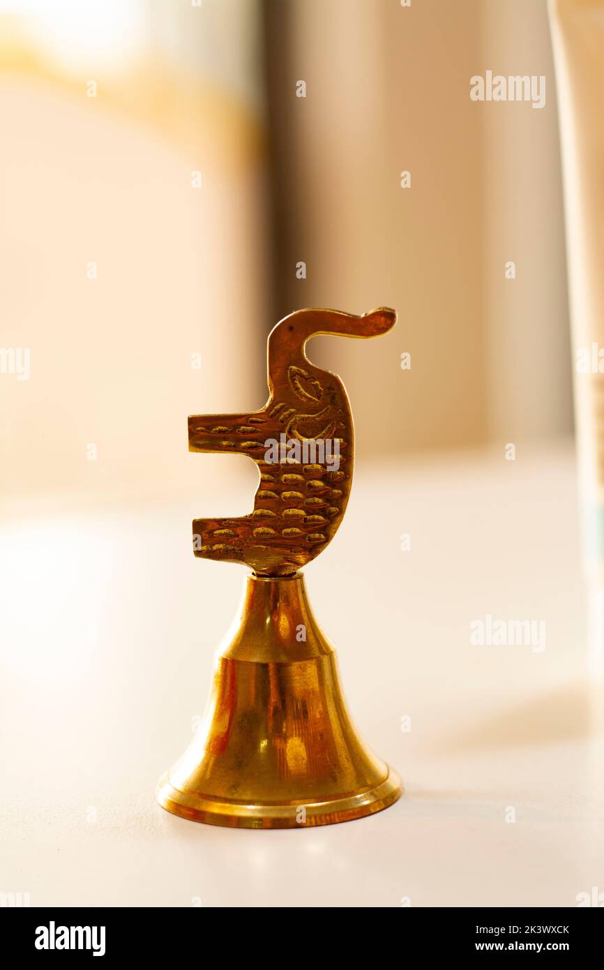A vertical shot of a golden elephant bell on the white background with ...