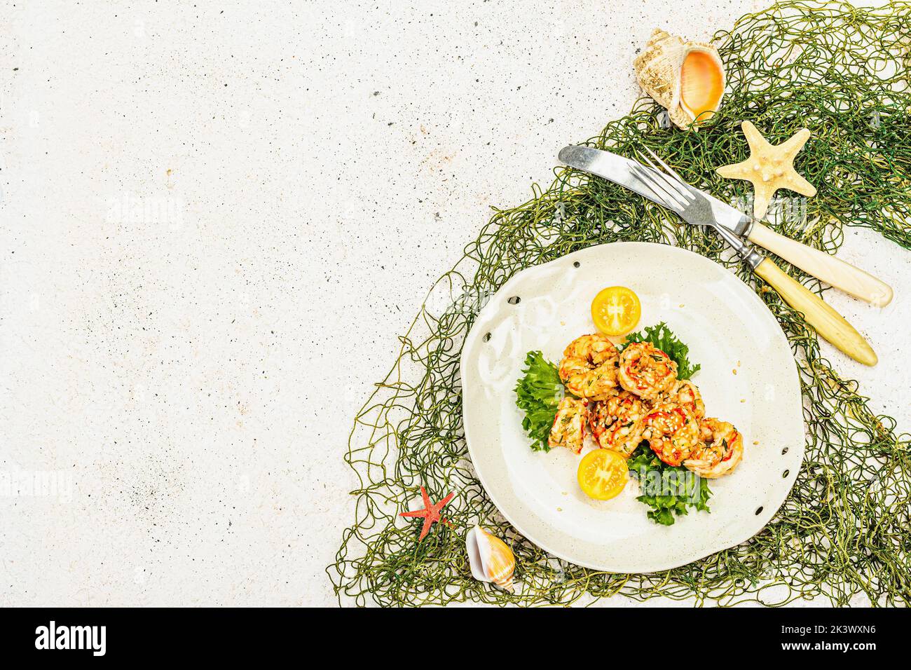 Grilled shrimp salad with lettuce, tomato cherries and spices on a ...