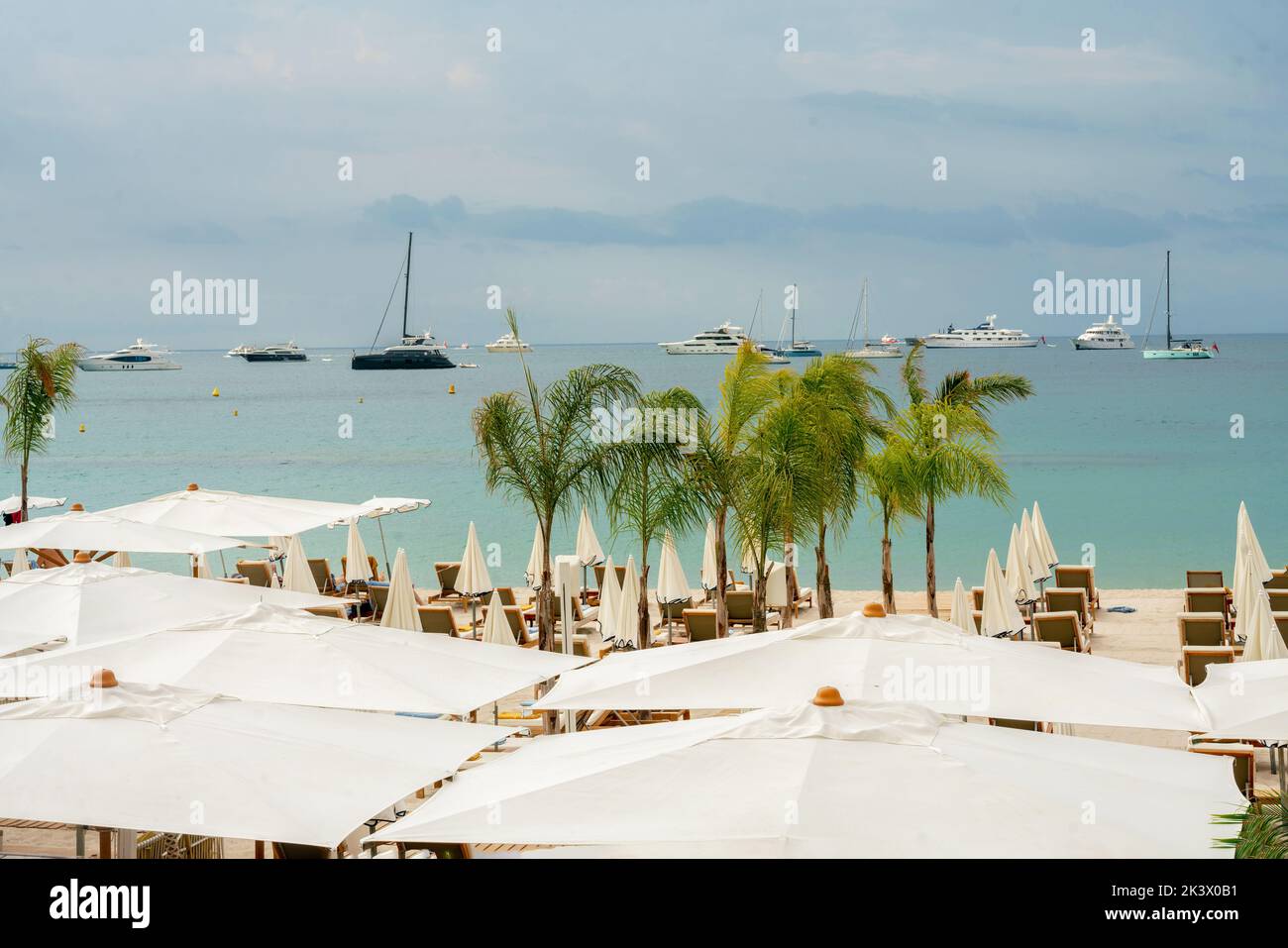 Beach in Cannes (French Riviera) with sun loungers and umbrellas, small ...