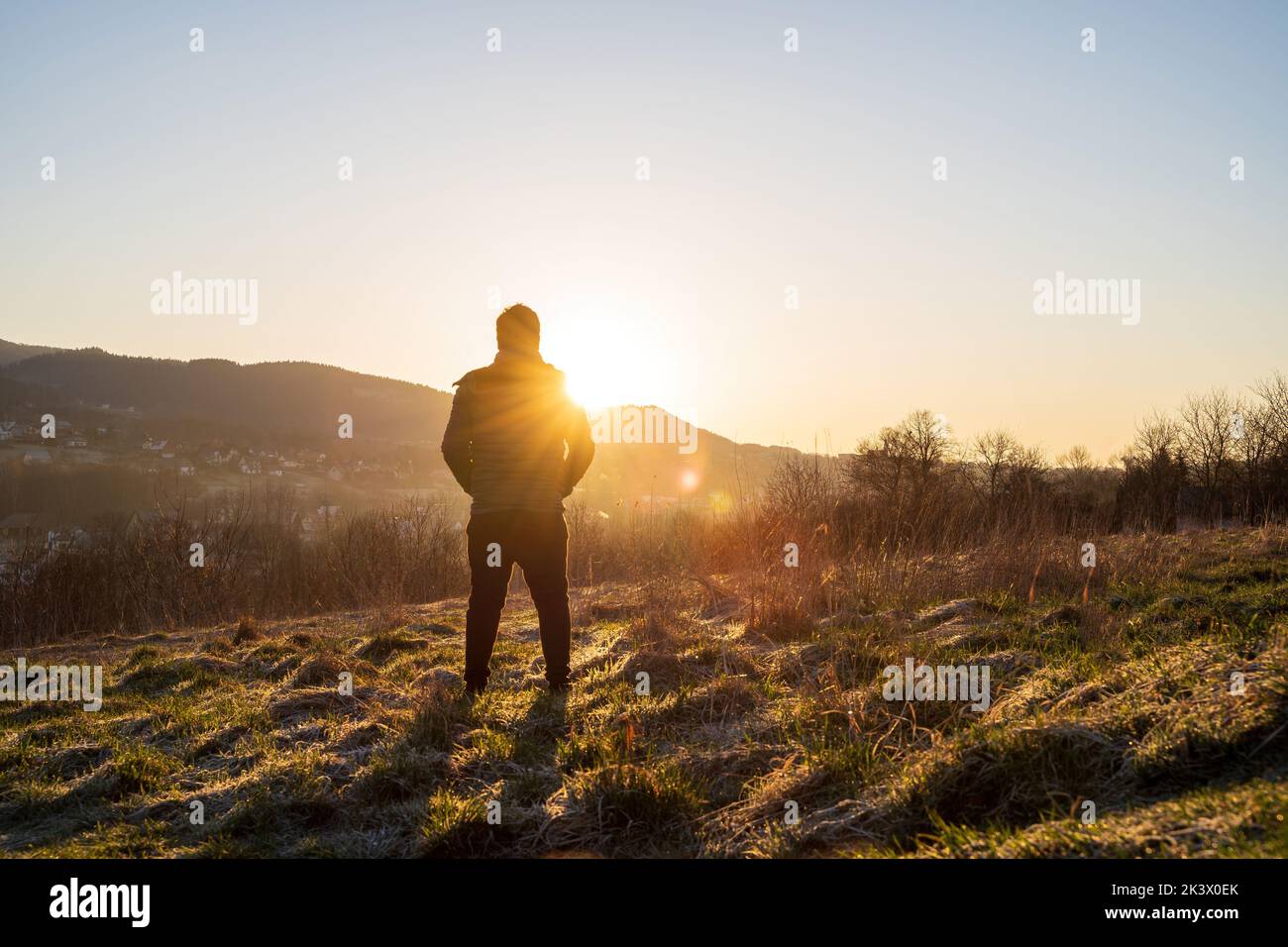 Wide angle shot of a man from behind facing a view of a landscape ...