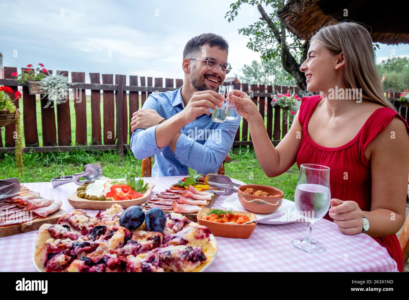 Happy young romantic couple toasting with shots of brandy with a ...