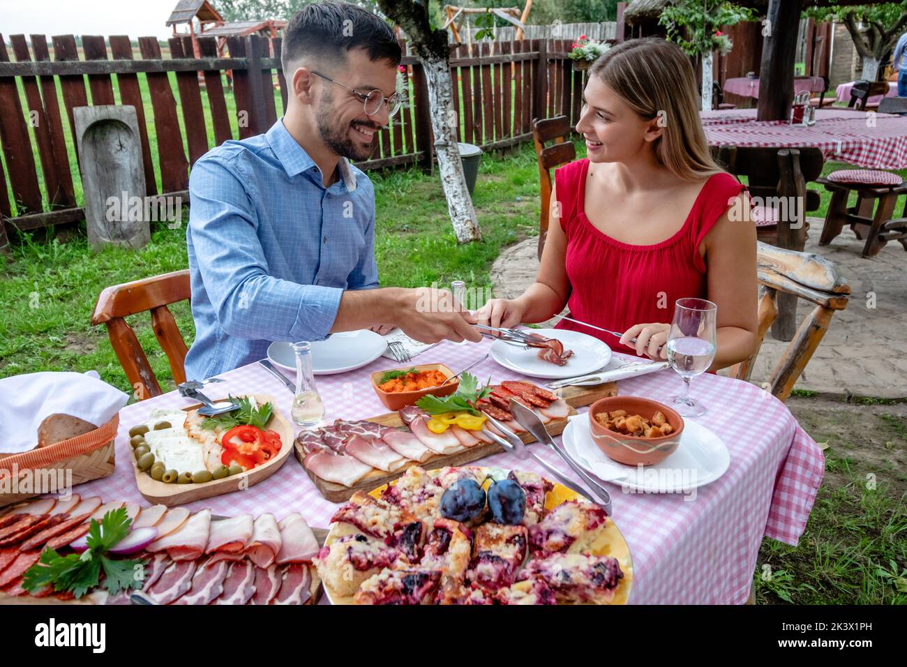 Happy young romantic couple having lunch or dinner in a beautiful open ...