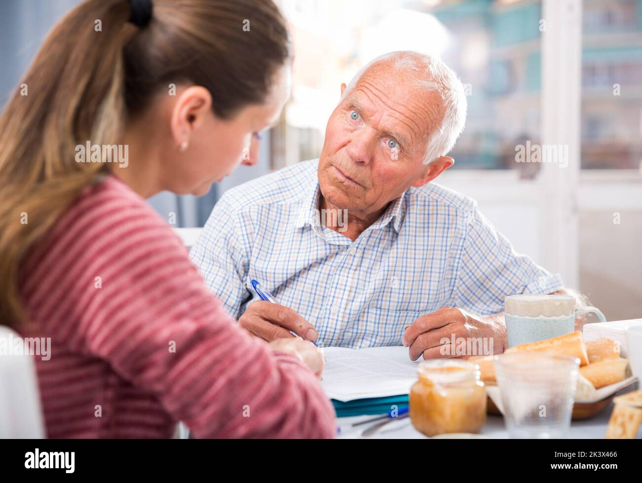 Mature father and adult daughter fill out paperwork Stock Photo - Alamy