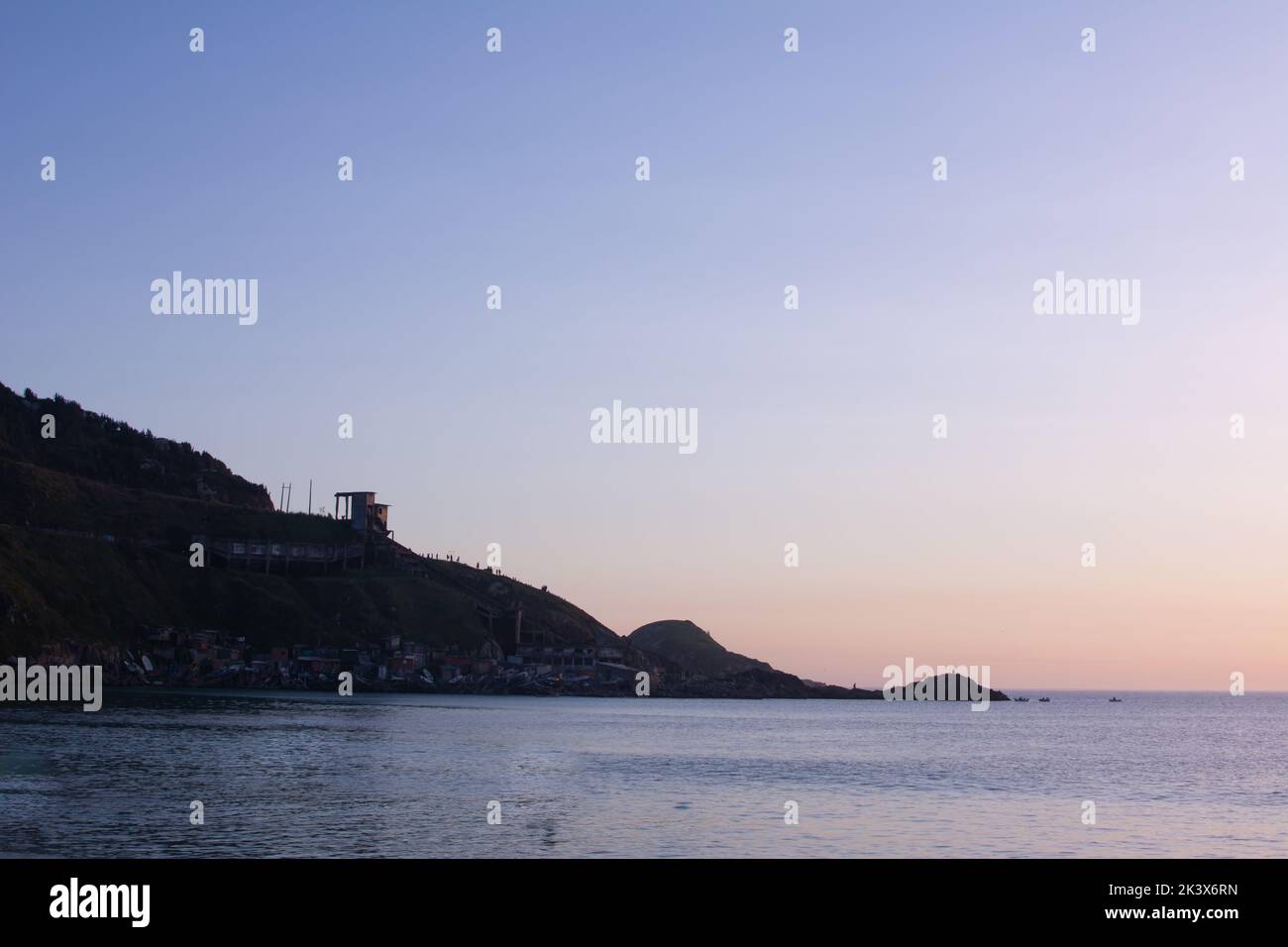 A landscape of a sea and hills at the blue hour Stock Photo - Alamy
