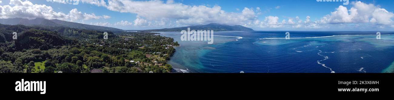 A panoramic aerial view of a tropical island with coral reefs and calm ...