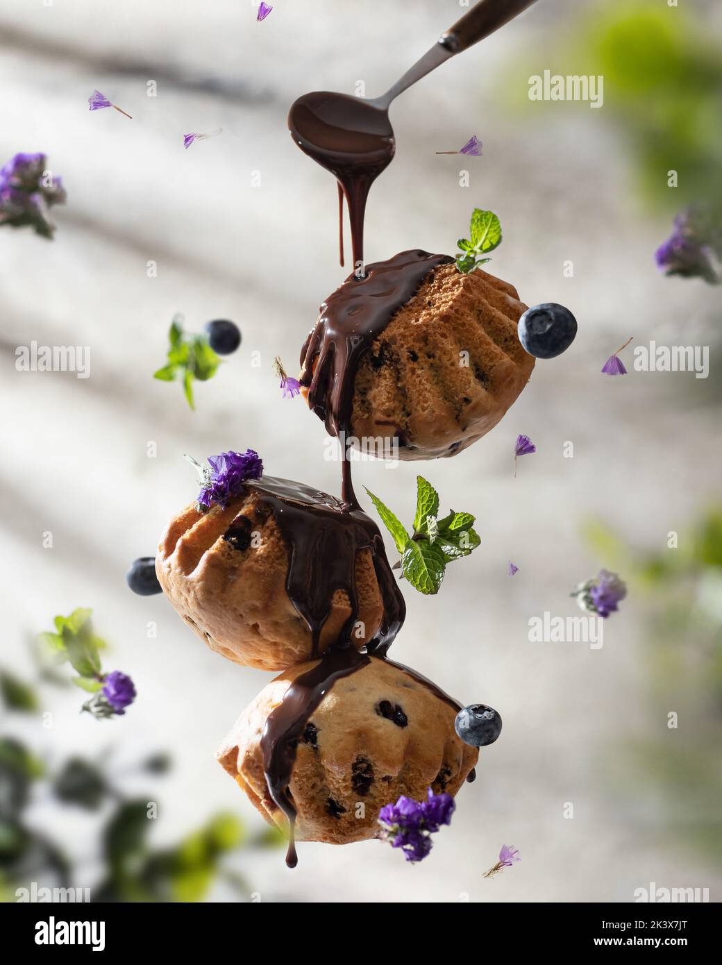 Delisious raisins muffins in levitaion with chocolate and berries ...