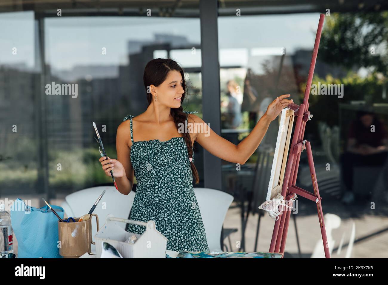 Young beautiful female artist with tools posing for camera Stock Photo ...