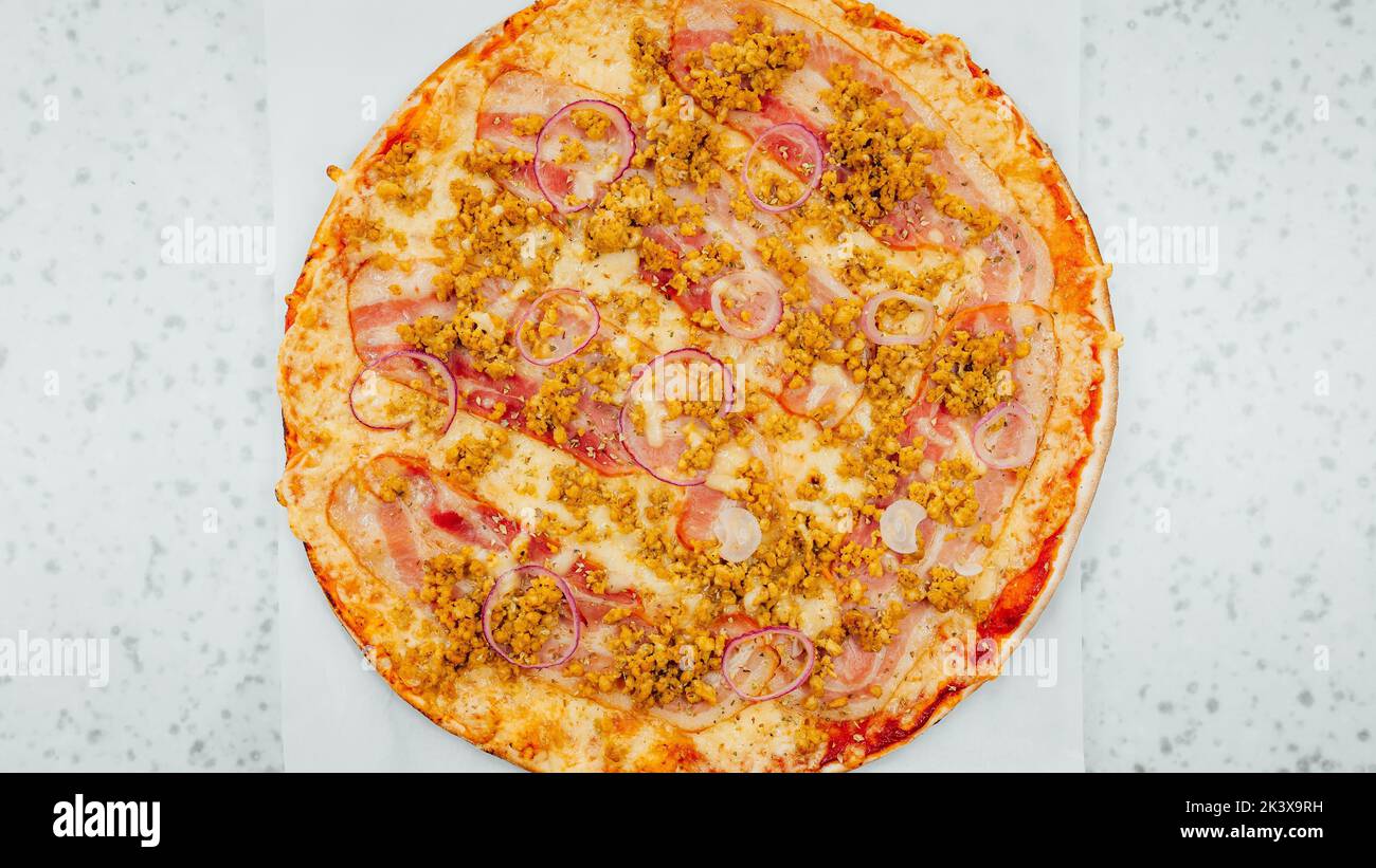 A top view of an appetizing pizza topping with bacon and onions and ...