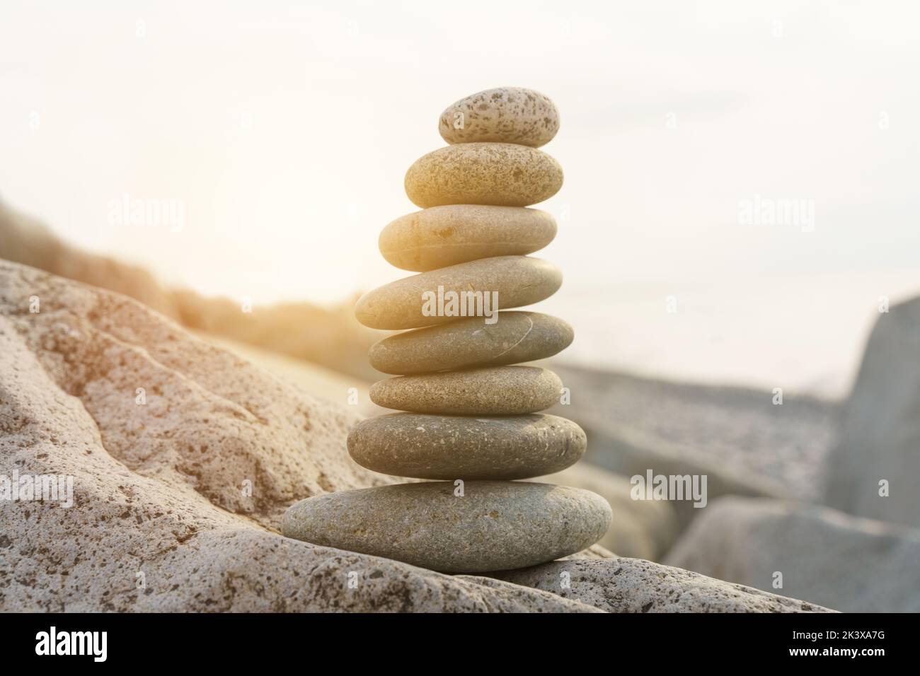 Pyramid stones balance on the beach in the sun. The concept of rest and ...