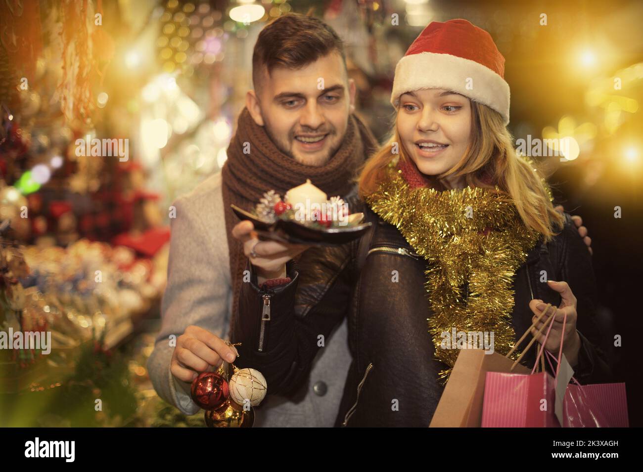 Joyful young couple in Christmas hat delighted with purchases Stock ...
