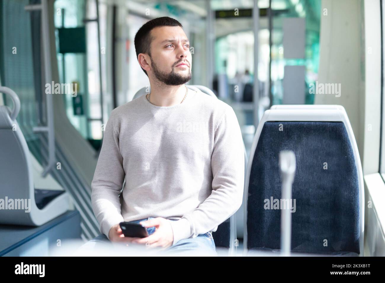 Young man using smartphone during trip in public transport Stock Photo ...
