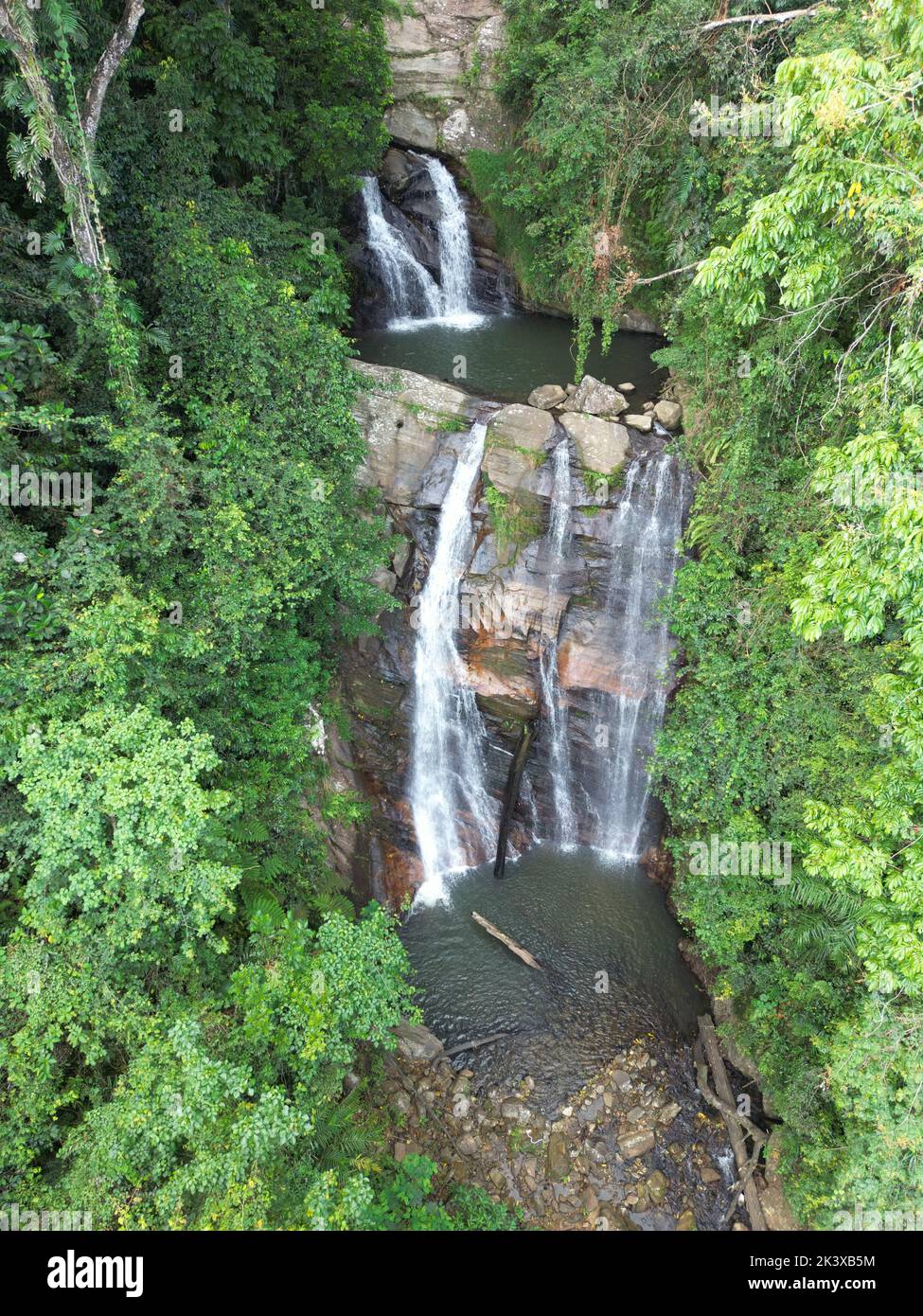 A vertical shot of beautiful two waterfalls with surrounding jungle ...