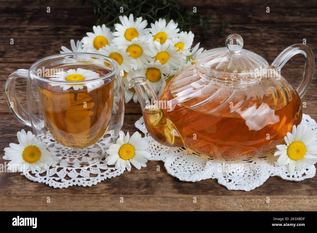 The concept of medicinal medical tea. Daisies on the table and tea in a ...