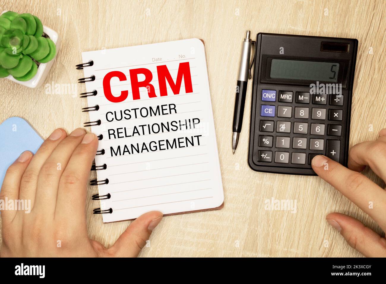 notepad with the text CRM Customer Relationship Management and pen on ...