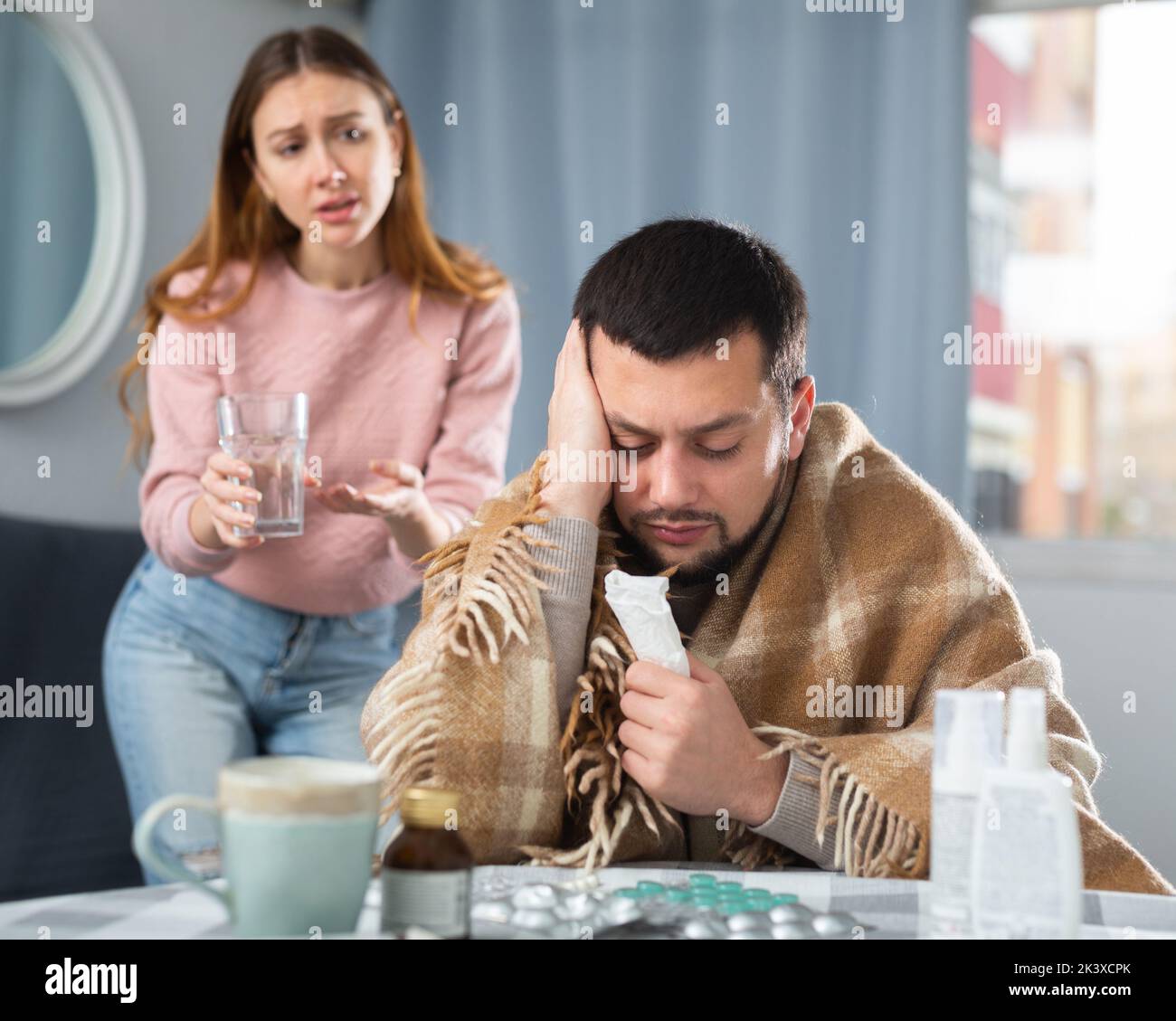 Wife carrying glass of water for her husband who got sick with flu ...