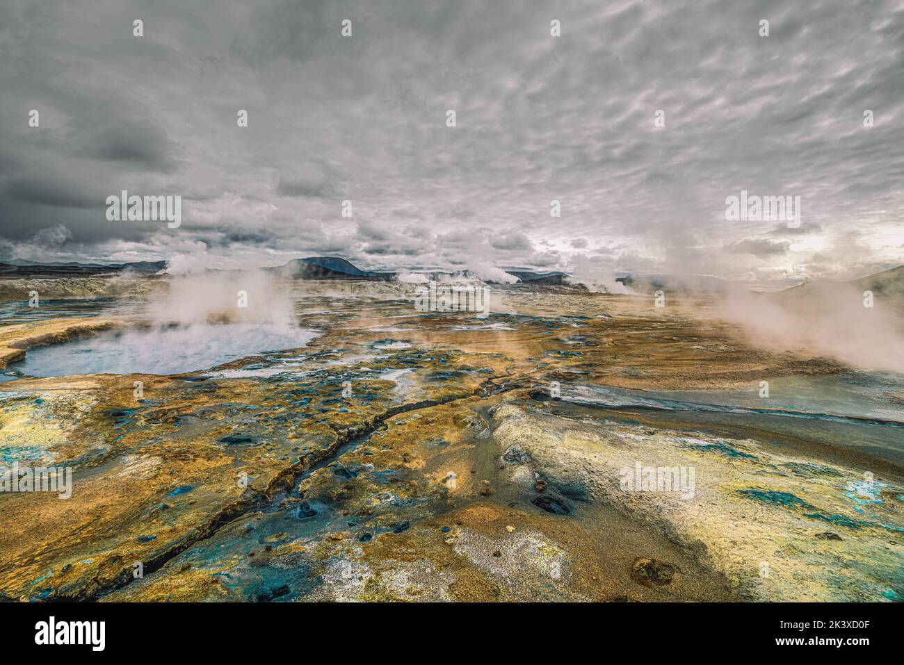A panoramic view of the natural geysers landscape with gray cloudy sky ...