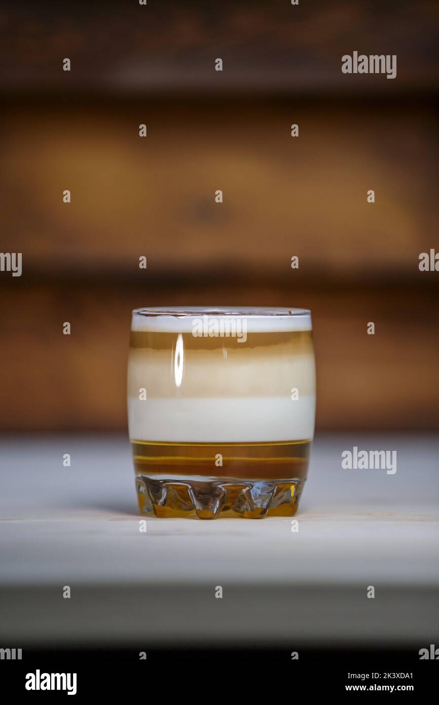 A shallow focus shot of glass Barraquito on a wooden background Stock ...