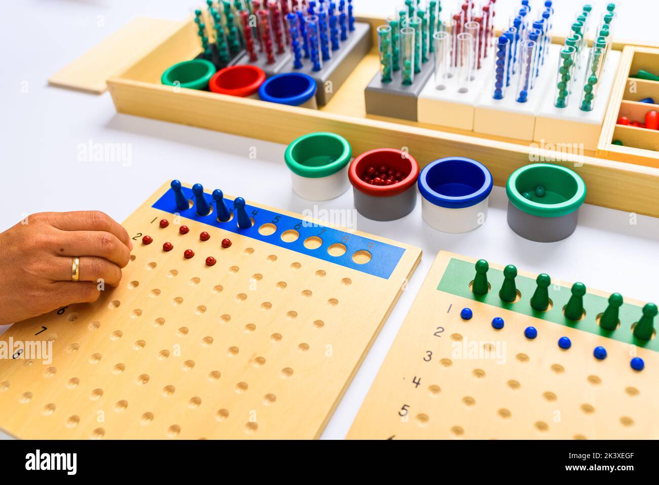 Detail of a montessori board division with the hand of a guide and ...