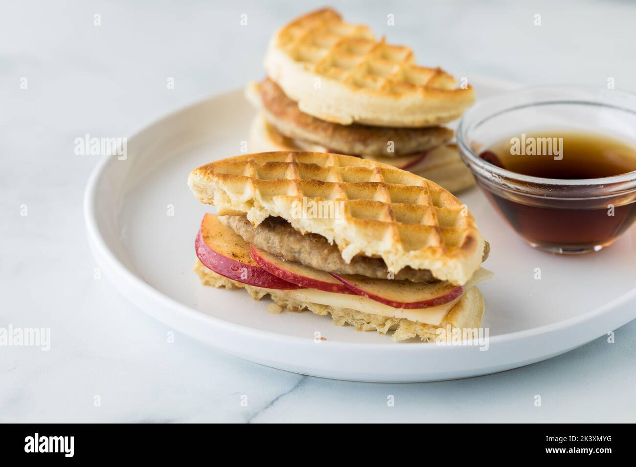 A waffle and sausage sandwich served with maple syrup for dipping Stock ...