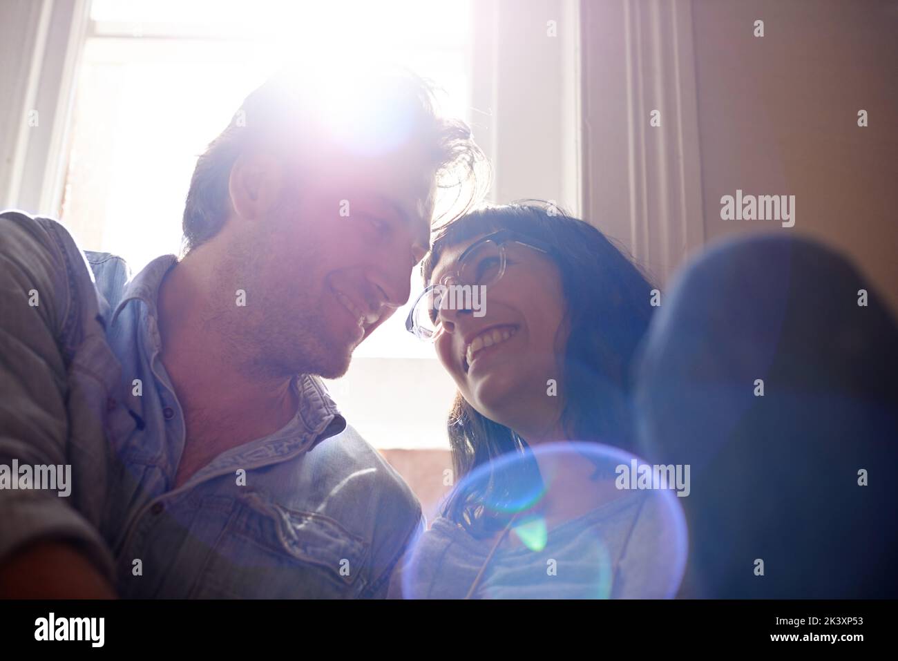 Sharing my life w. A happy couple sitting together in front of a window ...