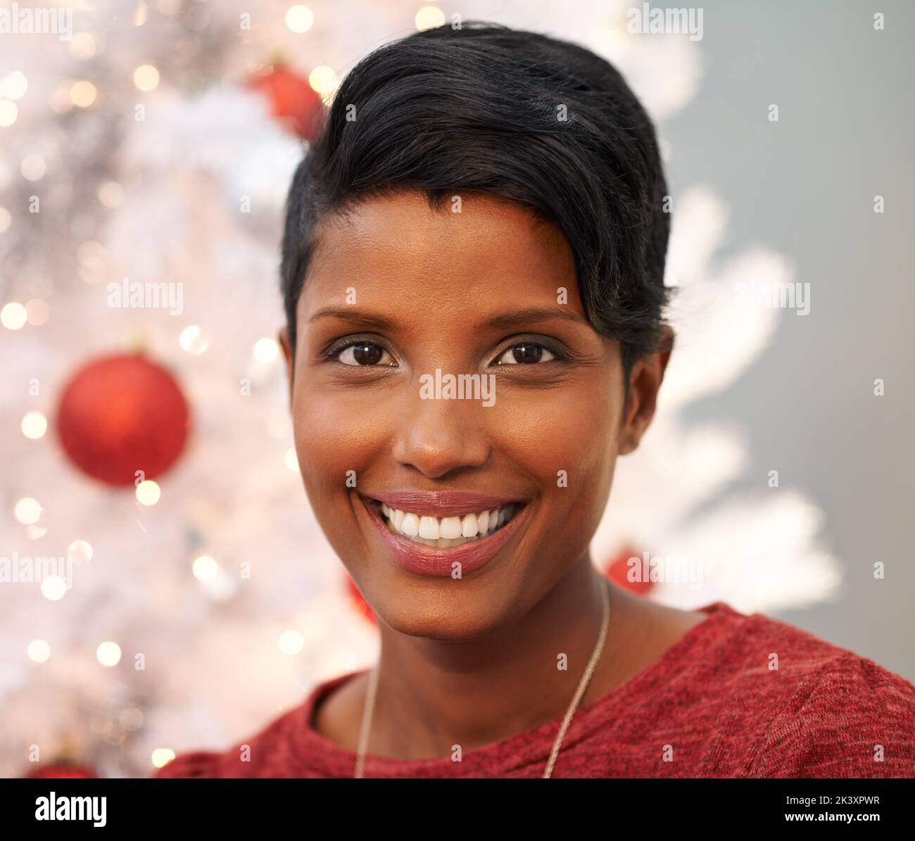 Excited about Christmas. Portrait of a beautiful young woman sitting by ...