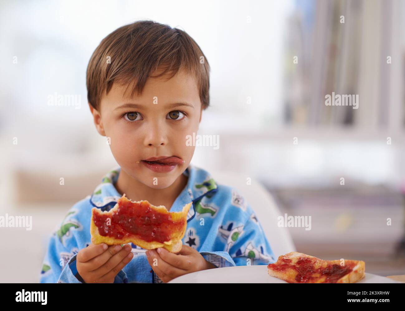 Nothing beats a good breakfast. A cute little boy eating toast with jam ...