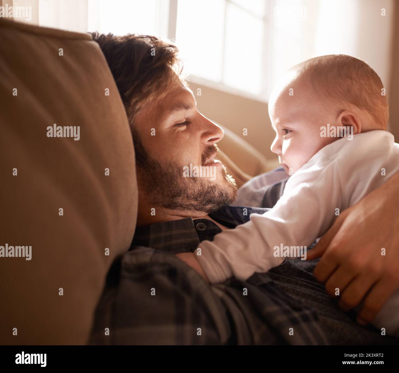 Cuddling with a cutie. an affectionate father bonding with his baby ...
