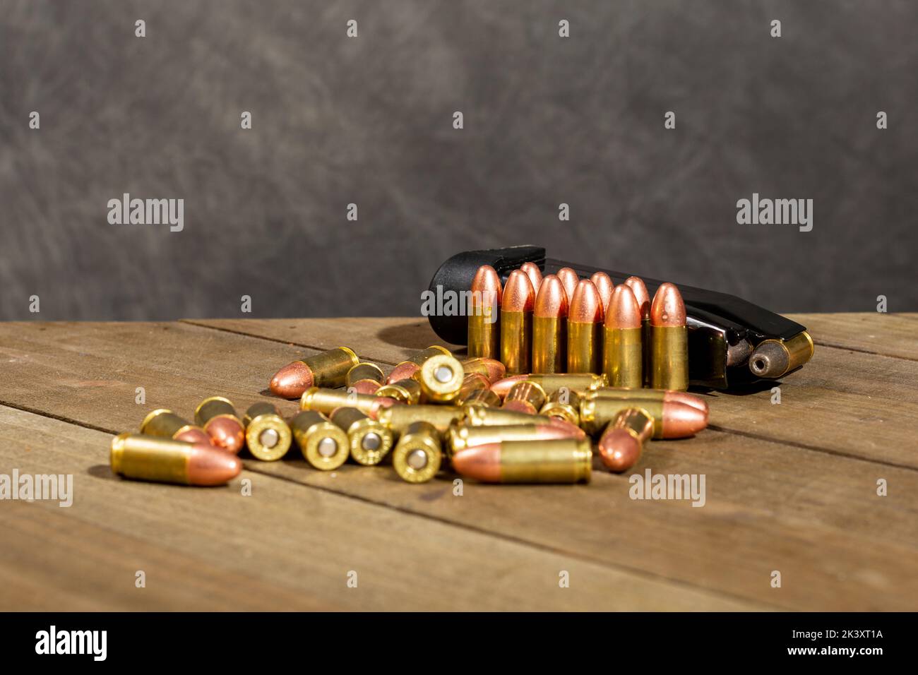 9 milimeter ammunition laying on the table next to a loaded magazine ...