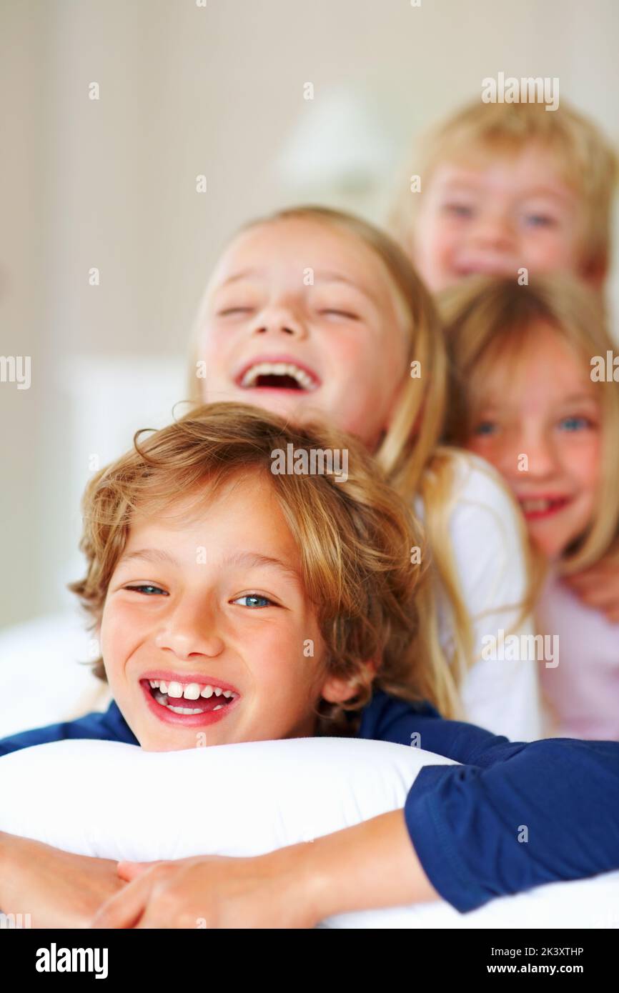Cheerful brothers and sisters having fun together in bed. Portrait of ...