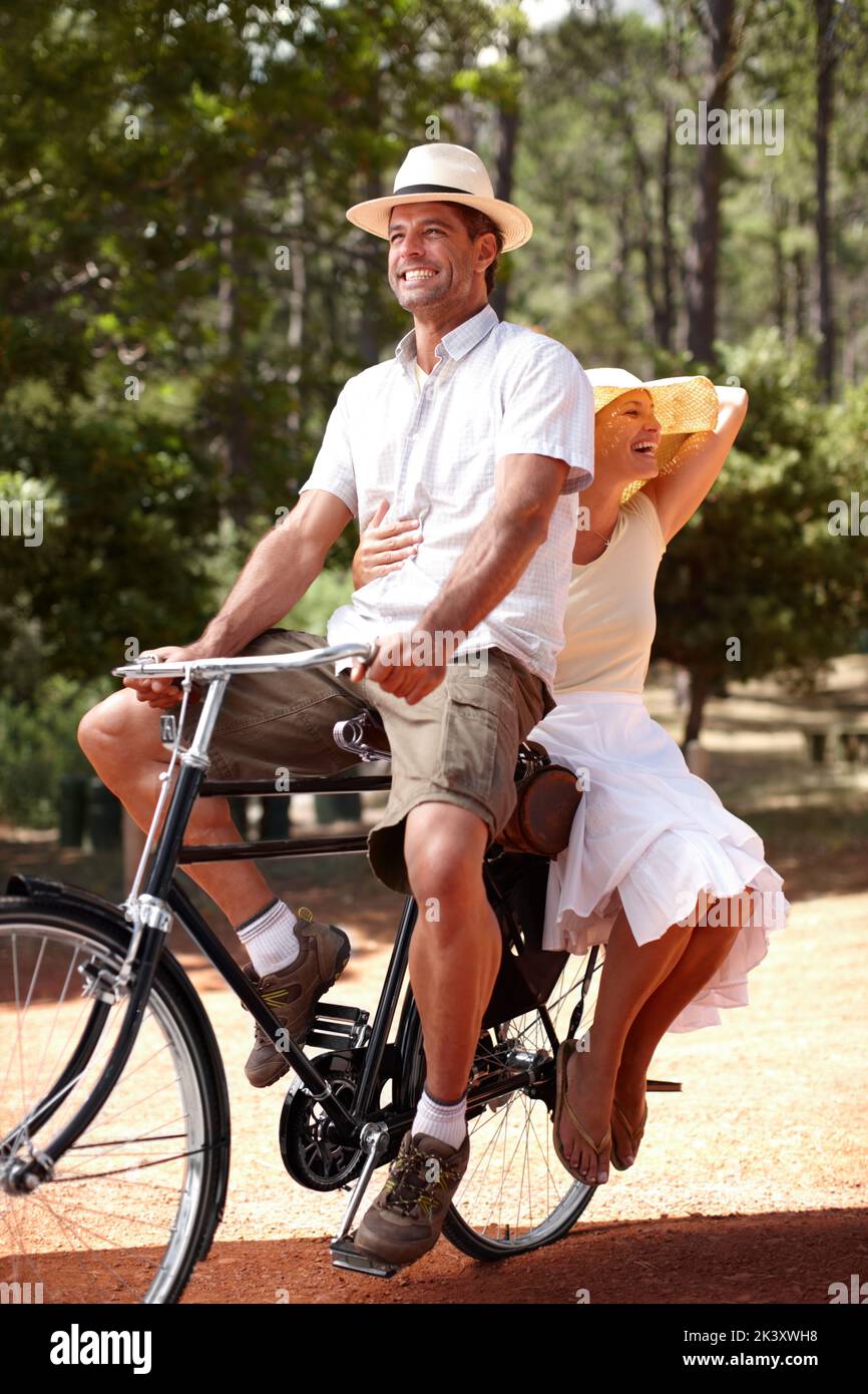 Casual countryside cycling. Playful couple having fun while riding on ...