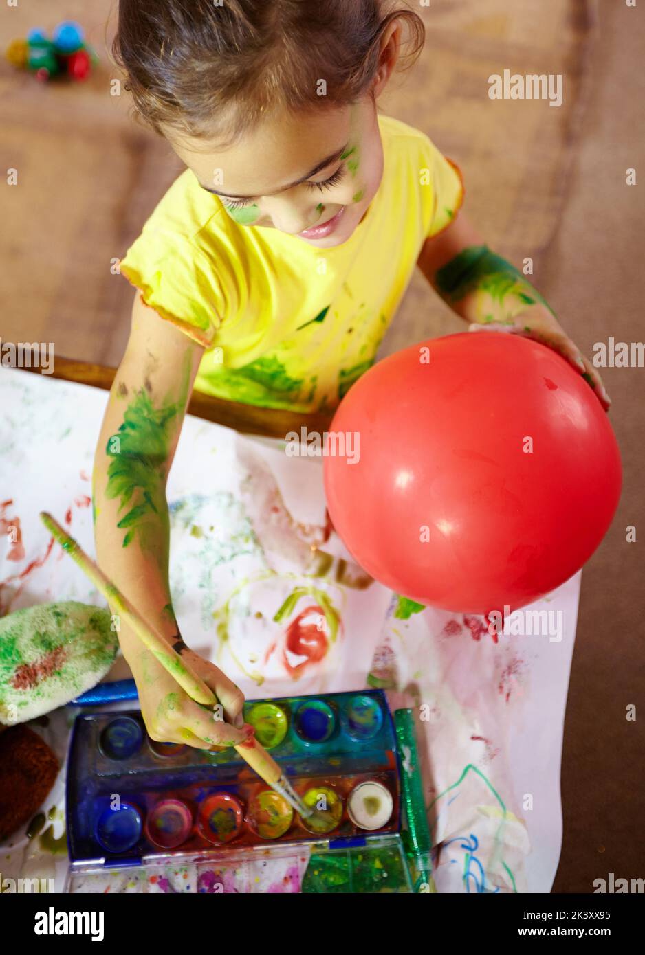 Bringing her creativity to life. an adorable little girl making a mess ...