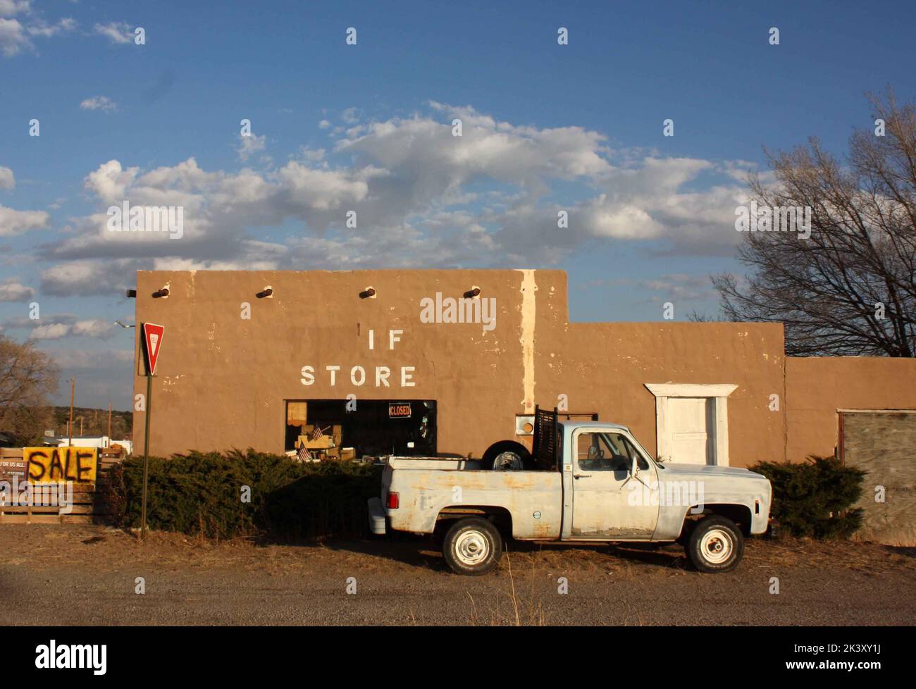 Old truck parked outside an old adobe ThrIFt store at closing time ...