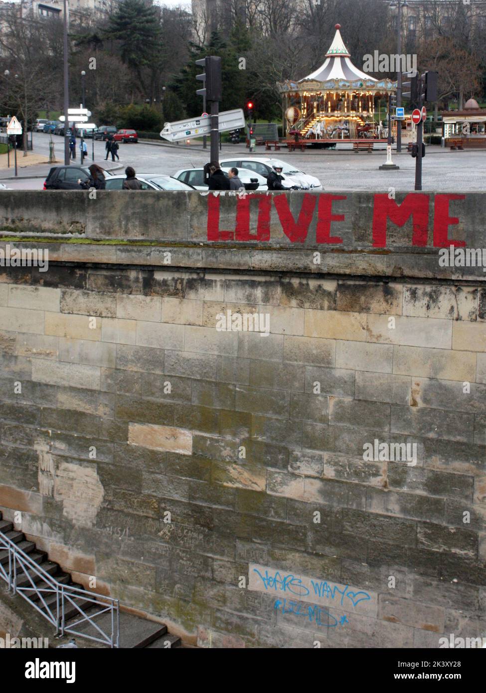 Brightly lit carousel and LOVE ME graffiti add color to Paris’ Seine ...