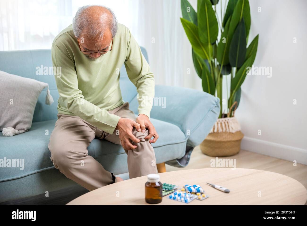 Old age. Asian senior man retirement knee joint pain on sofa, Elderly ...