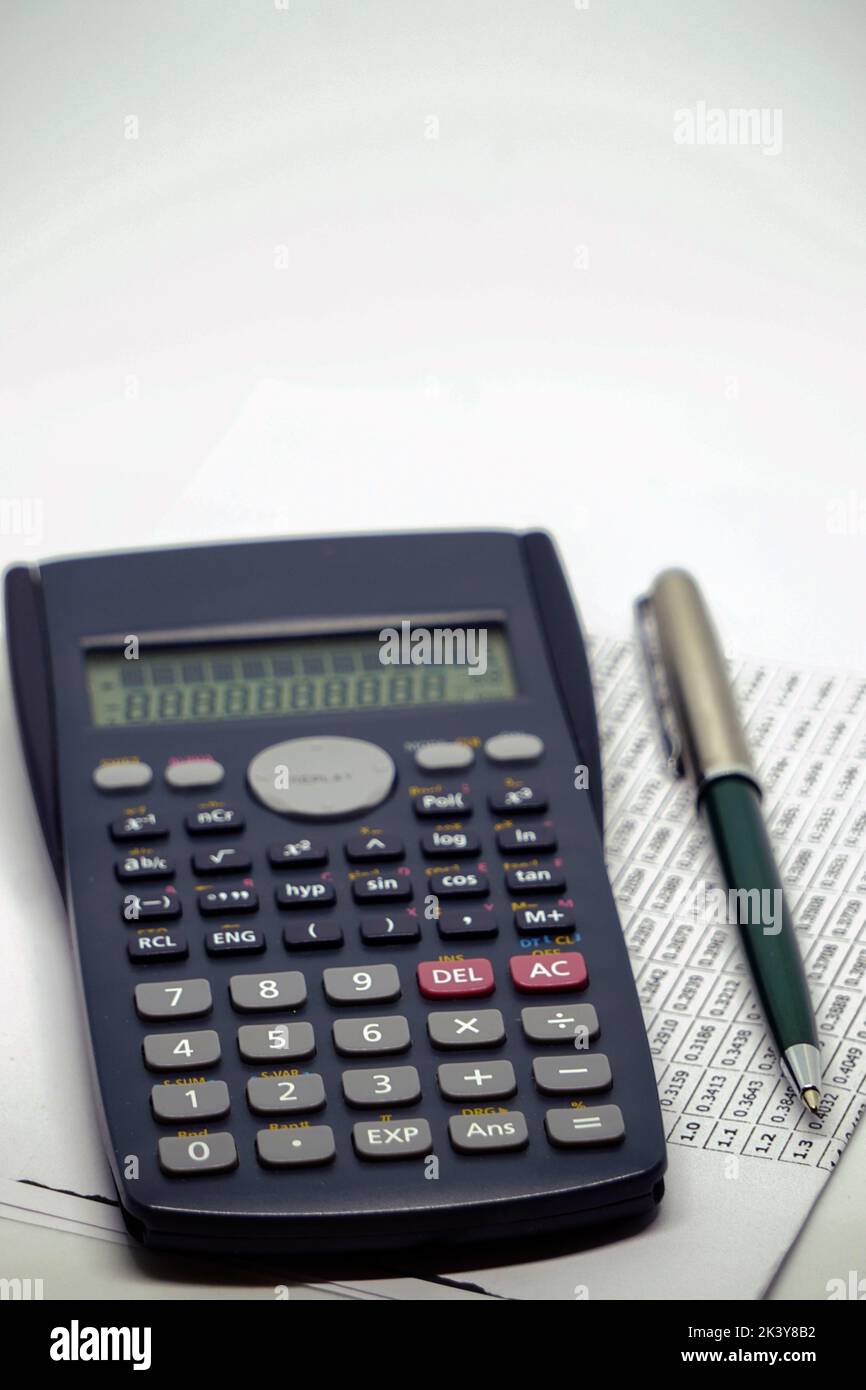 A calculator and pen on statistics chart, isolated on white background ...