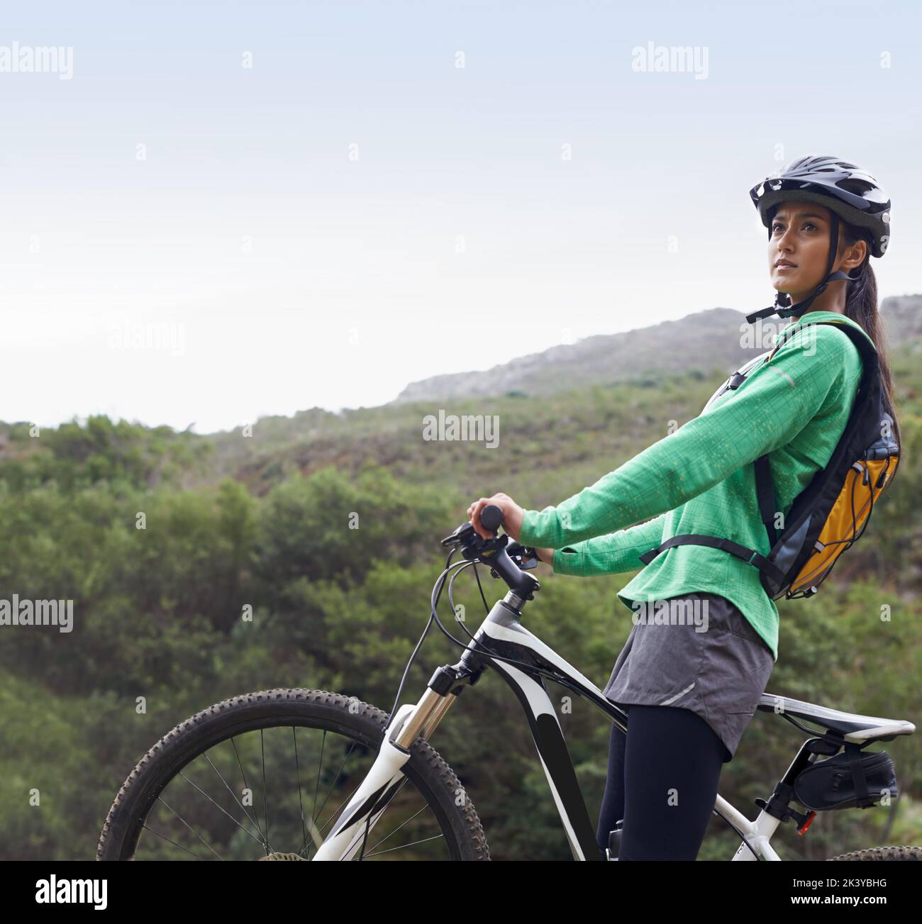 I love mountain biking. A pretty young woman mountain biking in a ...