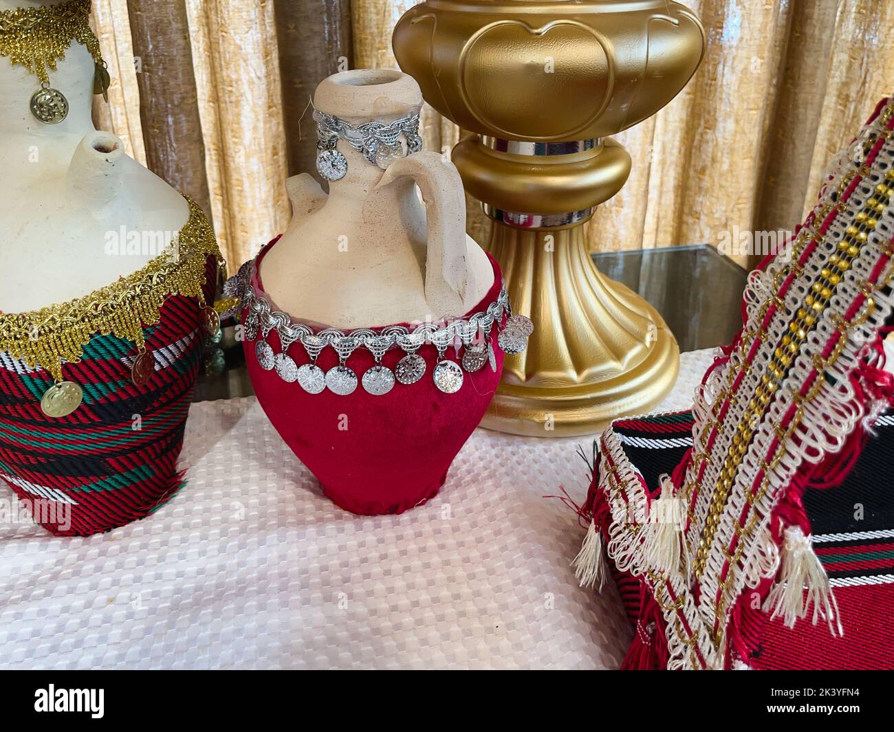 Brass bowls and jugs are covered with red fabric with handmade ...