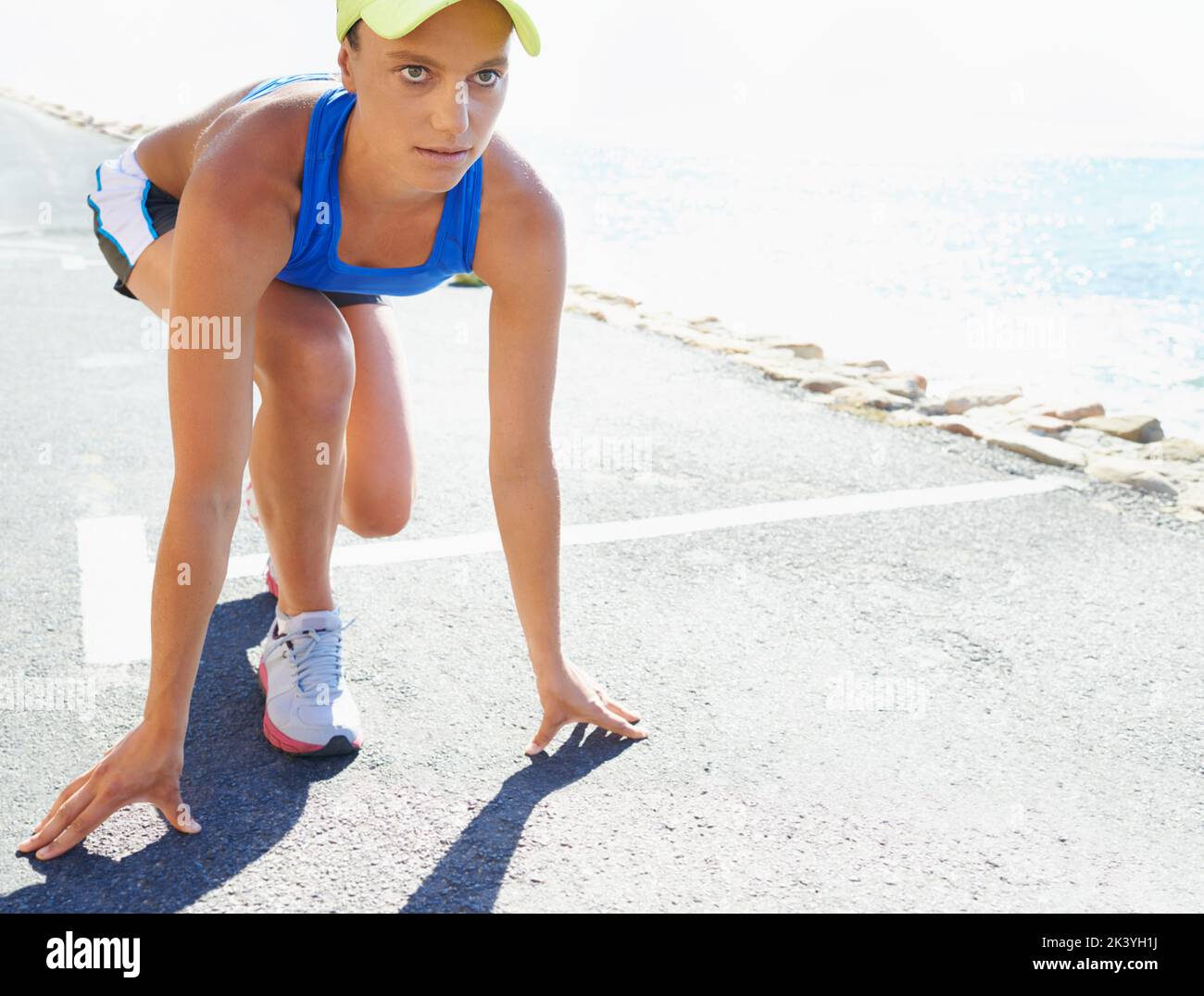 On her mark. A young woman ready on her mark to begin her morning run ...
