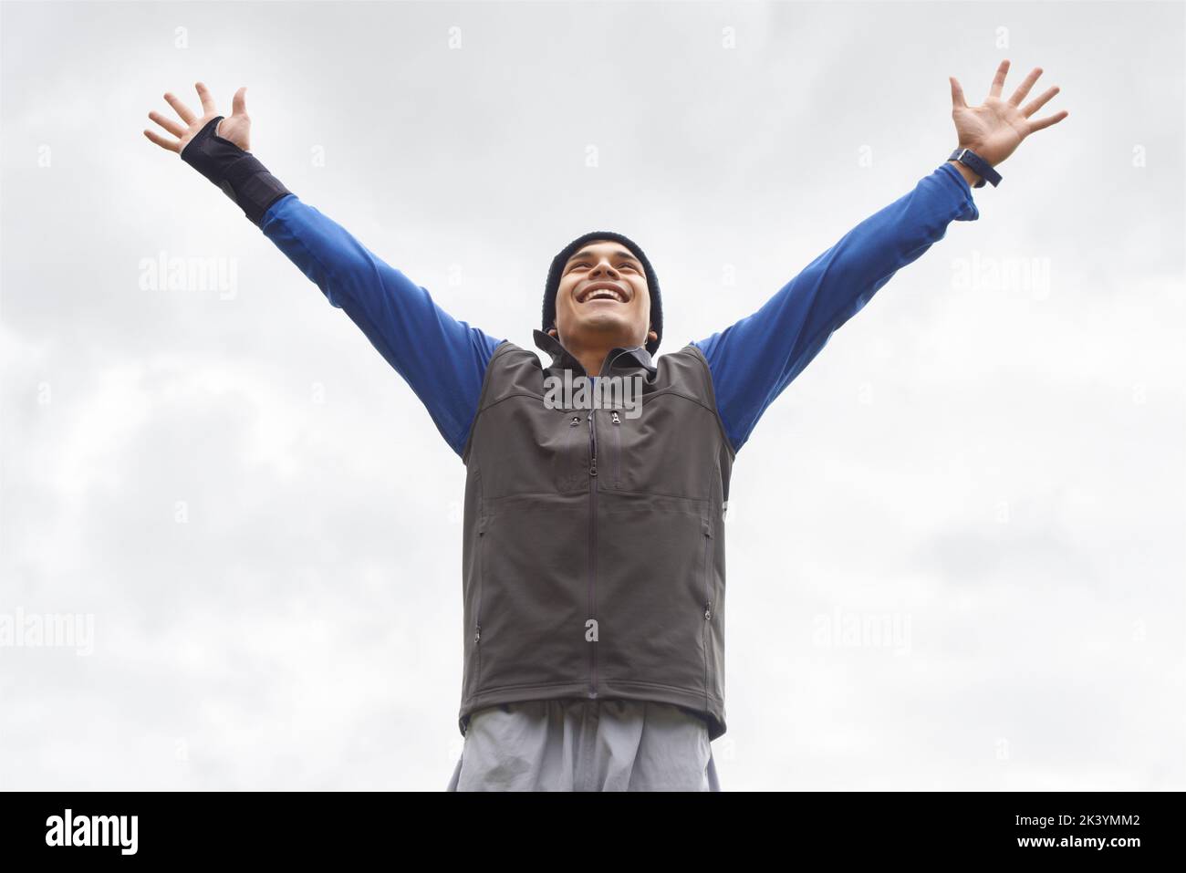 Ive made it. A young man celebrating at the top of a mountain after ...