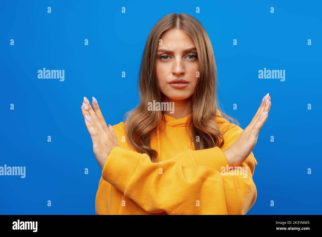 Portrait of attractive girl showing reject sign with crossed arms in ...