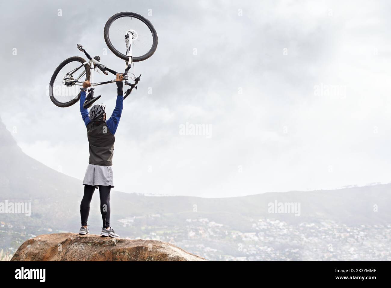 Another mountain cycled. A young man holding his mountain bike above ...