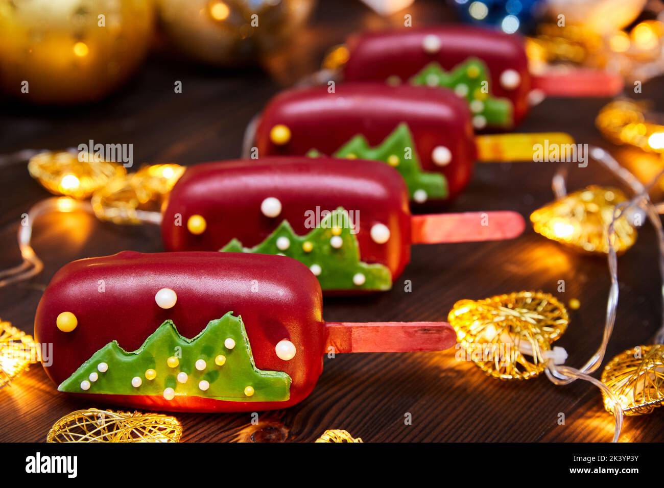 Red Christmas dessert in the form of mousse on a stick decorated with ...