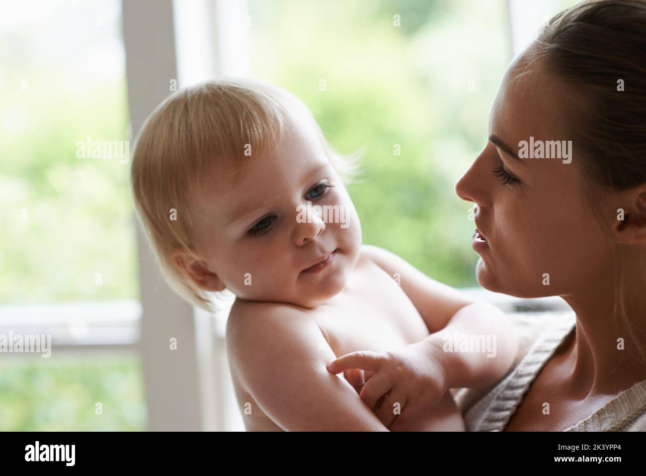 Safe in Mommys arms. A loving young mother holding her adorable baby ...