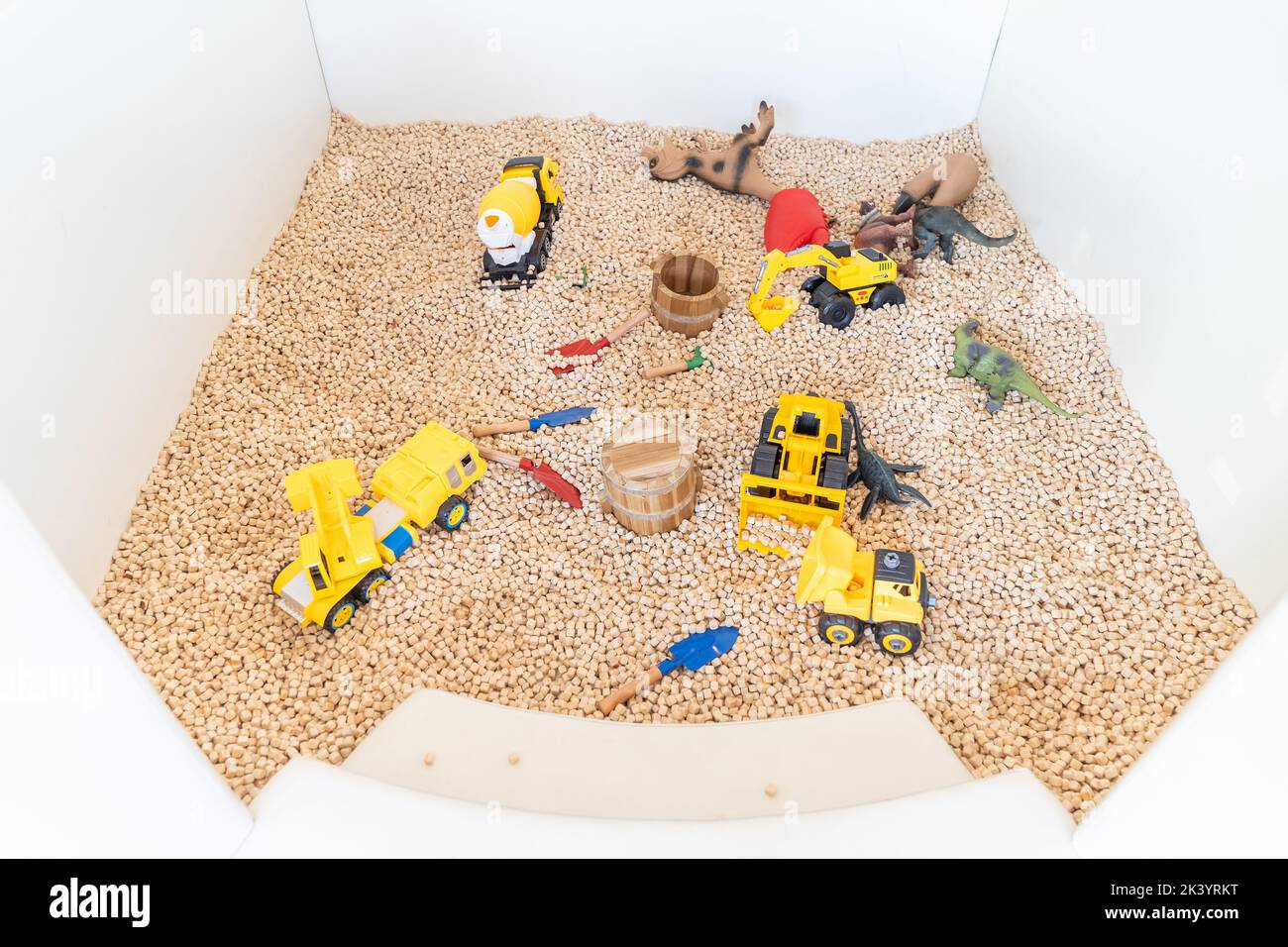 Yellow construction toy vehicles and Dinosaurs Toys are placed in kids ...