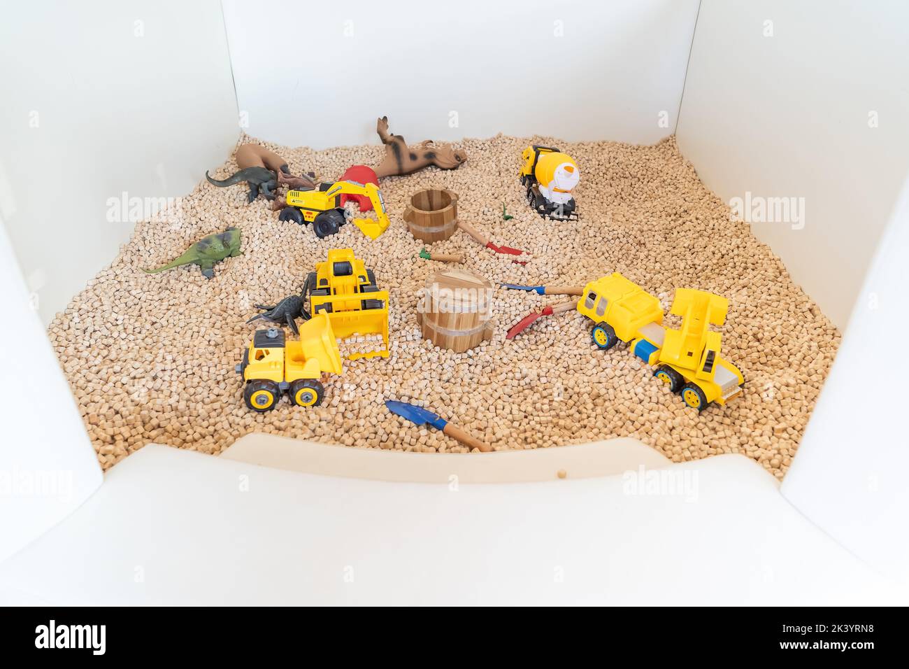 Yellow construction toy vehicles and Dinosaurs Toys are placed in kids ...