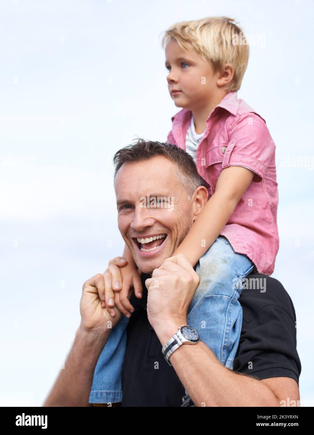Special moments with Dad. A handsome father carrying his son on his ...