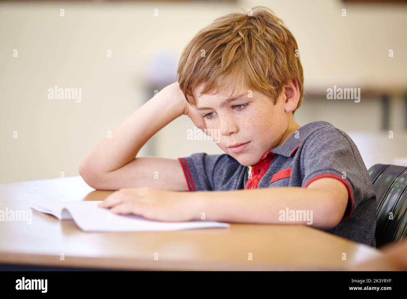 Classroom contemplations. A young student focused on his work while ...